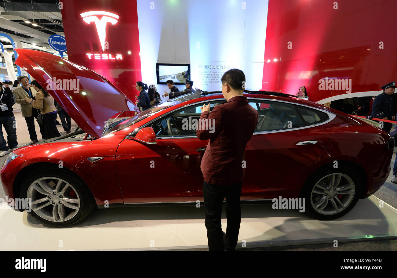 A visitor takes photos of a Tesla Model S electric car during the 2nd ...