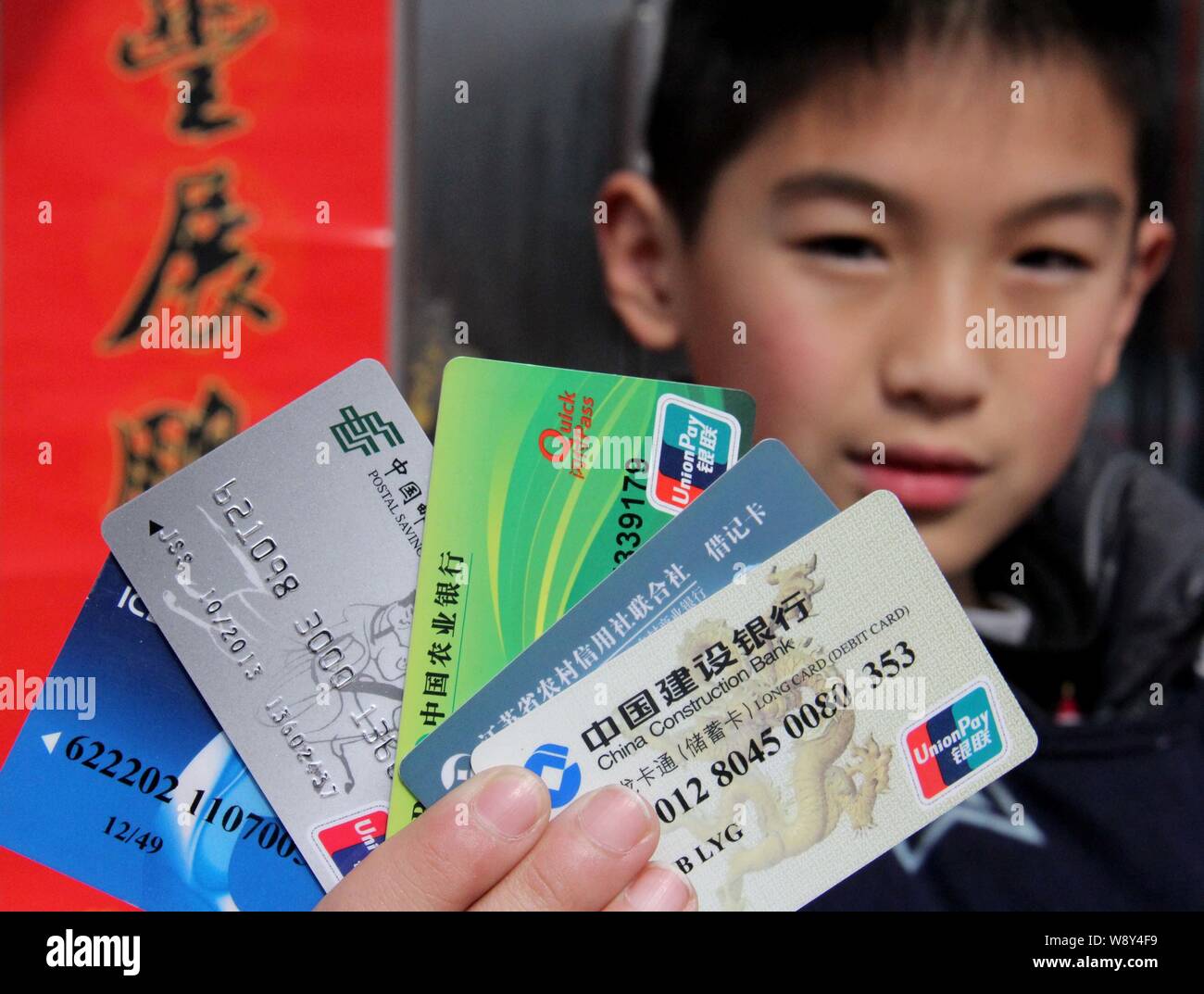 --FILE--A Chinese boy shows debit cards supported by China UnionPay in ...