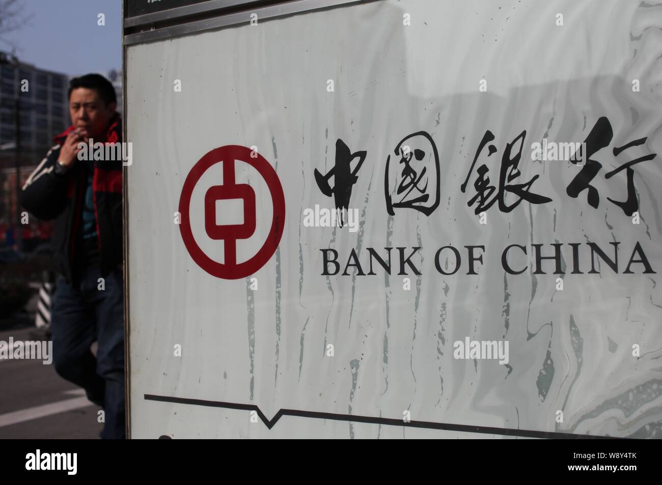 --FILE--A pedestrian walks past an advertisement for Bank of China (BOC ...