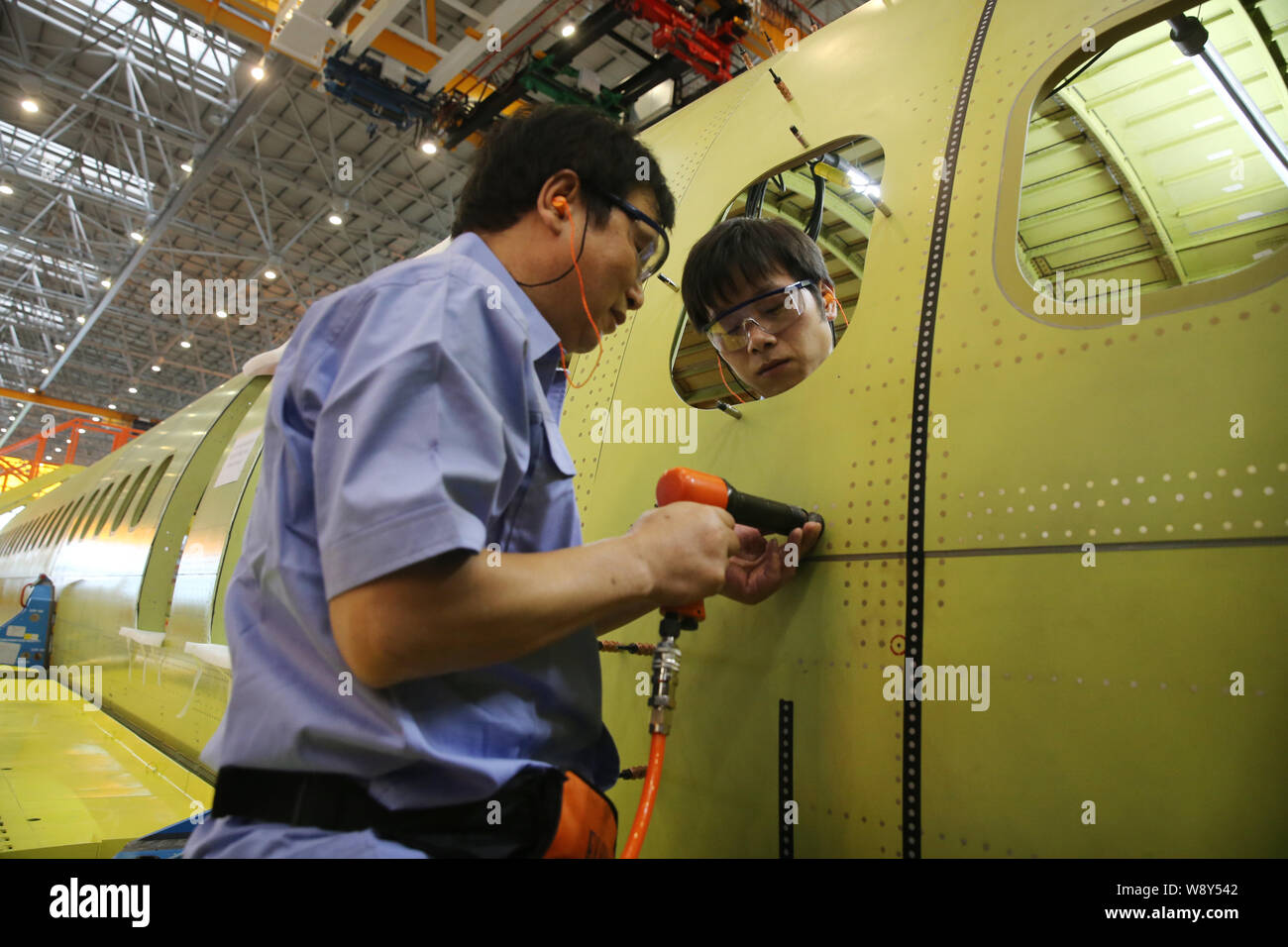 Chinese technicians rivet sections of the fuselage to assemble China¯s ...