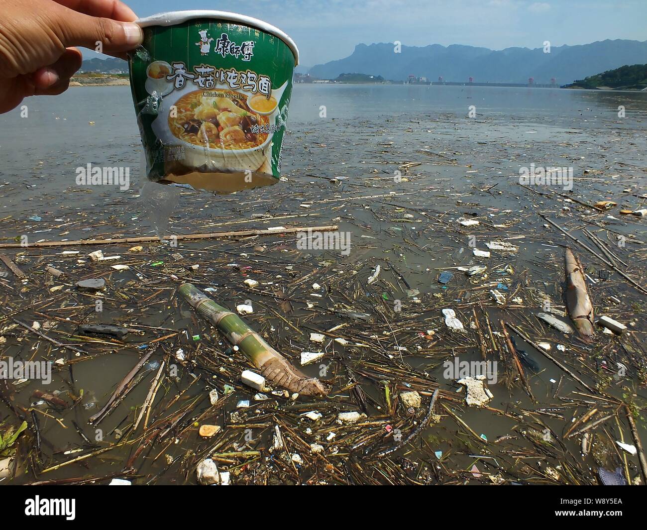 A Chinese worker shows wrappings of instant noodles collected from the ...