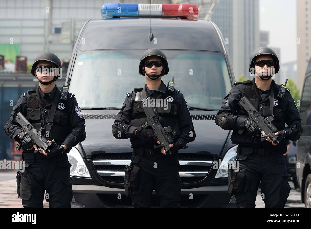 SWAT police officers armed with guns stand guard next to a police ...