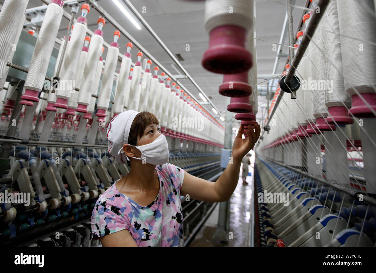 --FILE--A female Chinese worker handles production of yarn to be exported to Europe at a textile ...