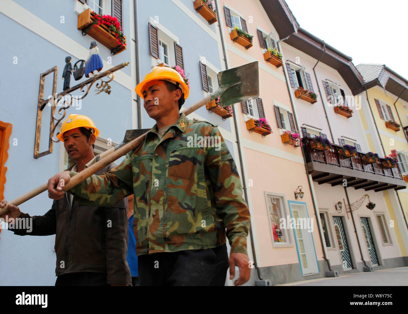 --FILE--Chinese workers walk past European-style houses in Hallstatt ...