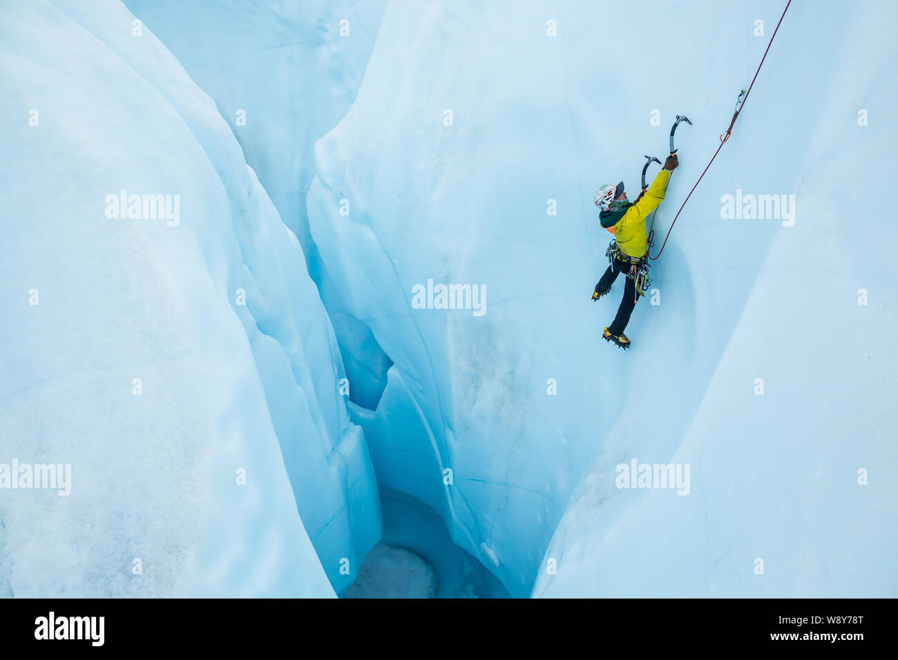 Ice climbing a steep line out of a large hole on glacier ice in Alaska ...