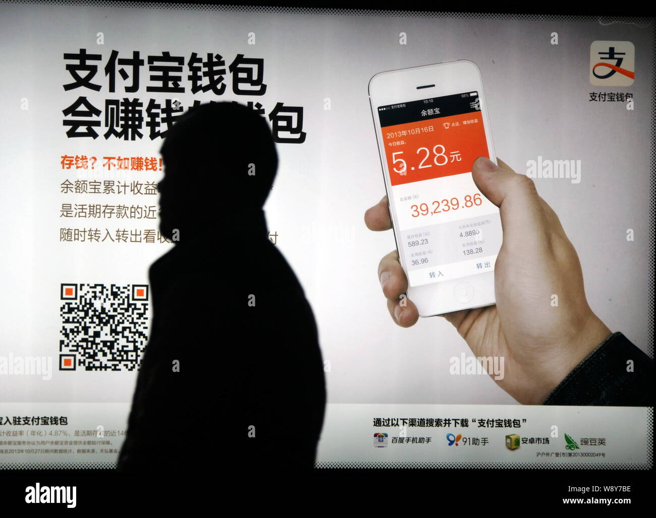--FILE--A pedestrian walks past an advertisement for Alipay Wallet and ...