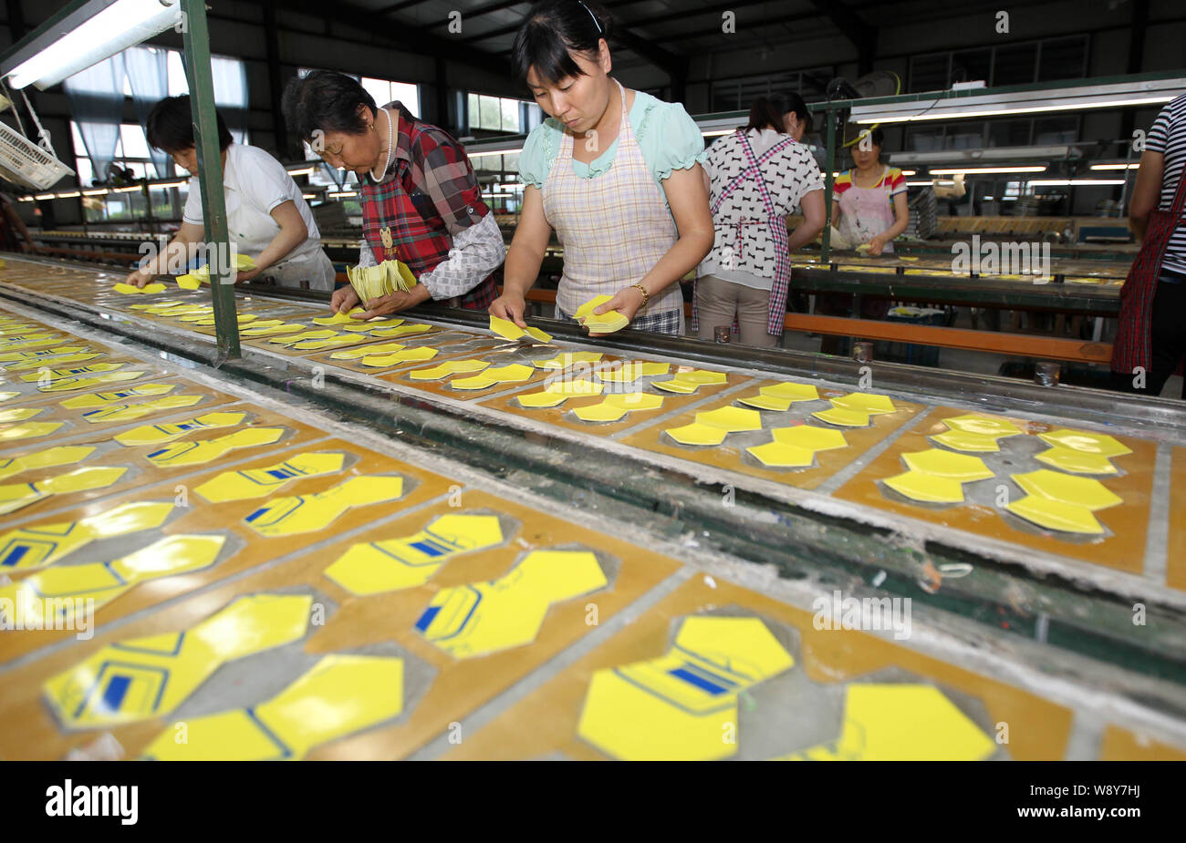 Chinese workers manufacture panels of footballs at a sports goods ...