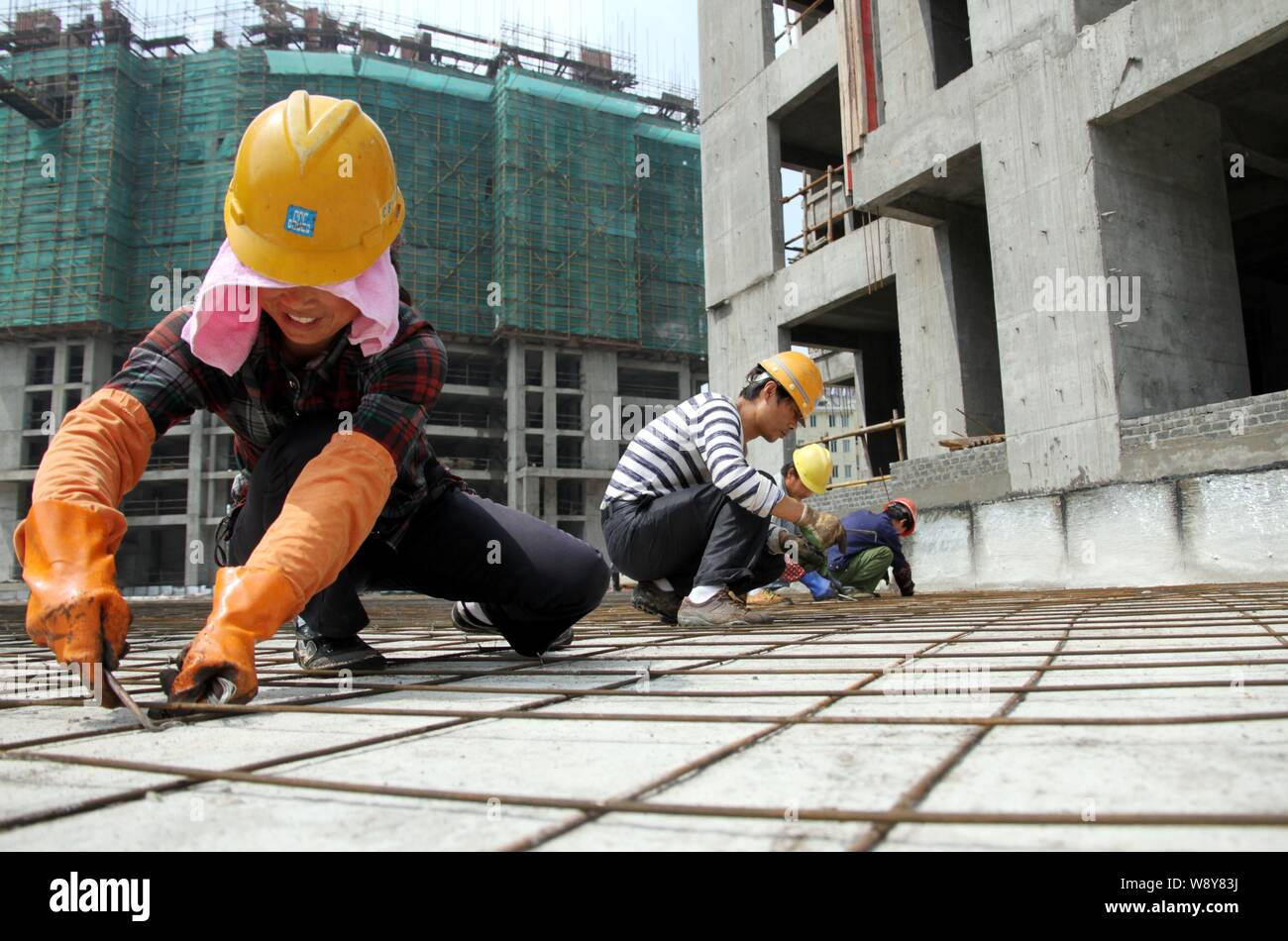 --FILE--Chinese migrant workers labor at the construction site of a ...