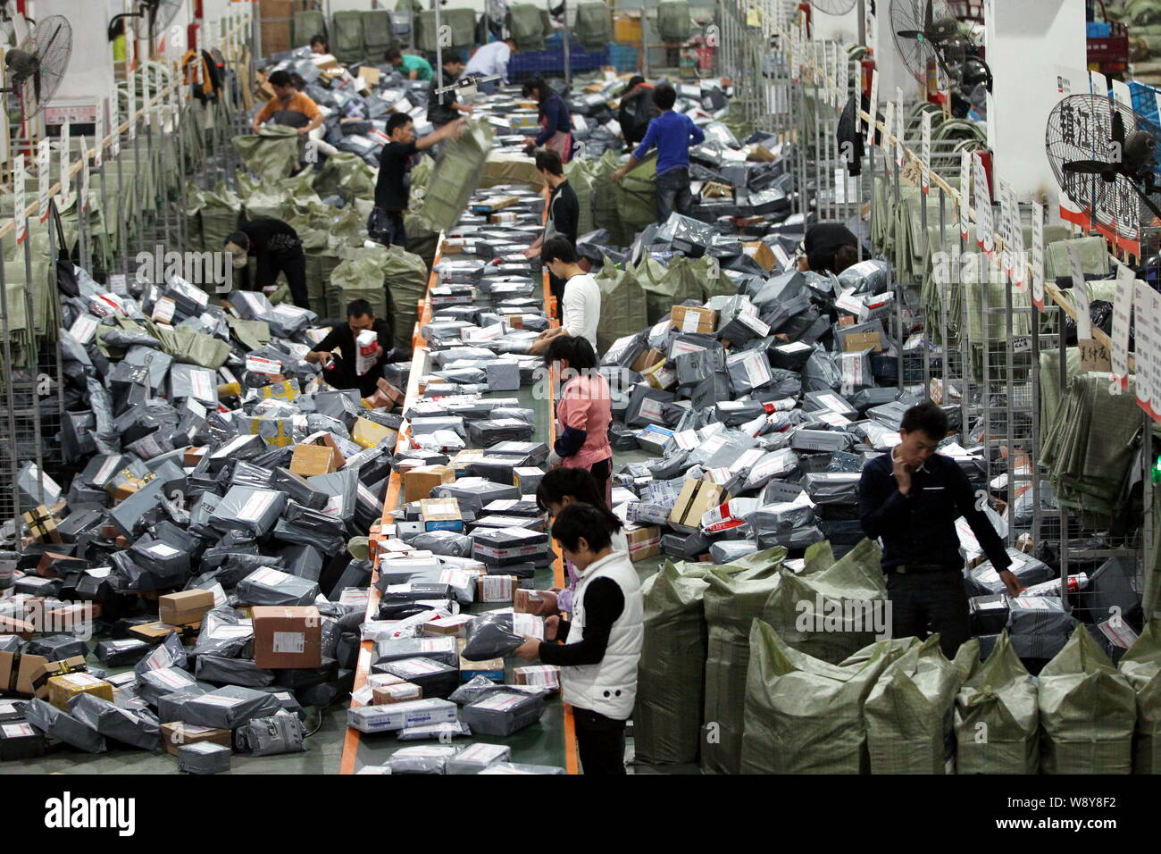 Chinese workers sort parcels, most of which are from online shopping ...