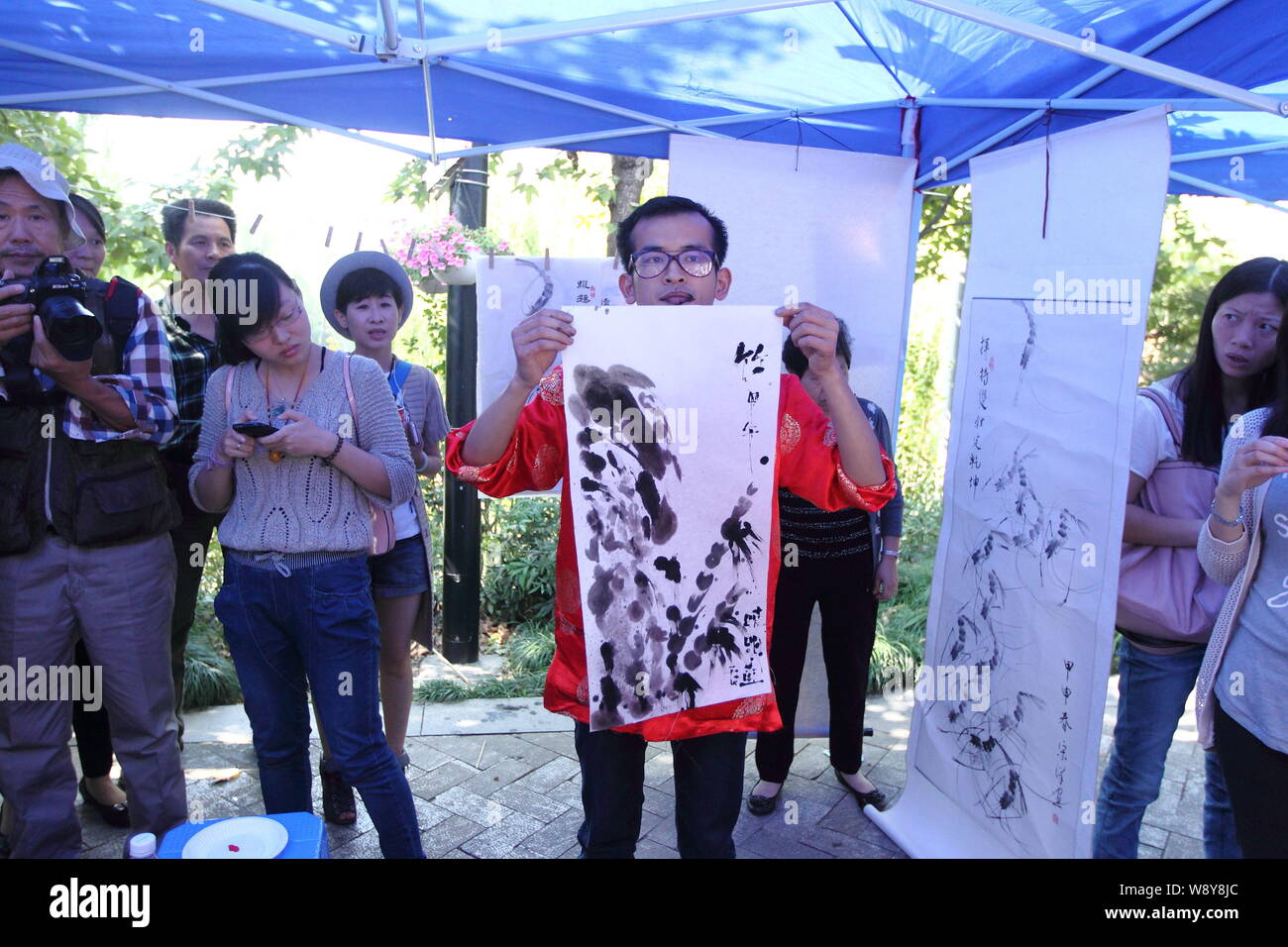 Chinese folk artist Han Xiaoming shows a painting he made with his ...