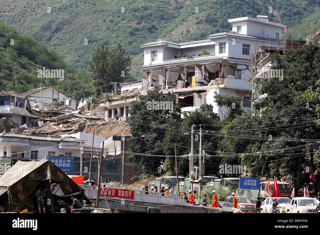 View of damaged apartment buildings and the debris of collapsed houses ...