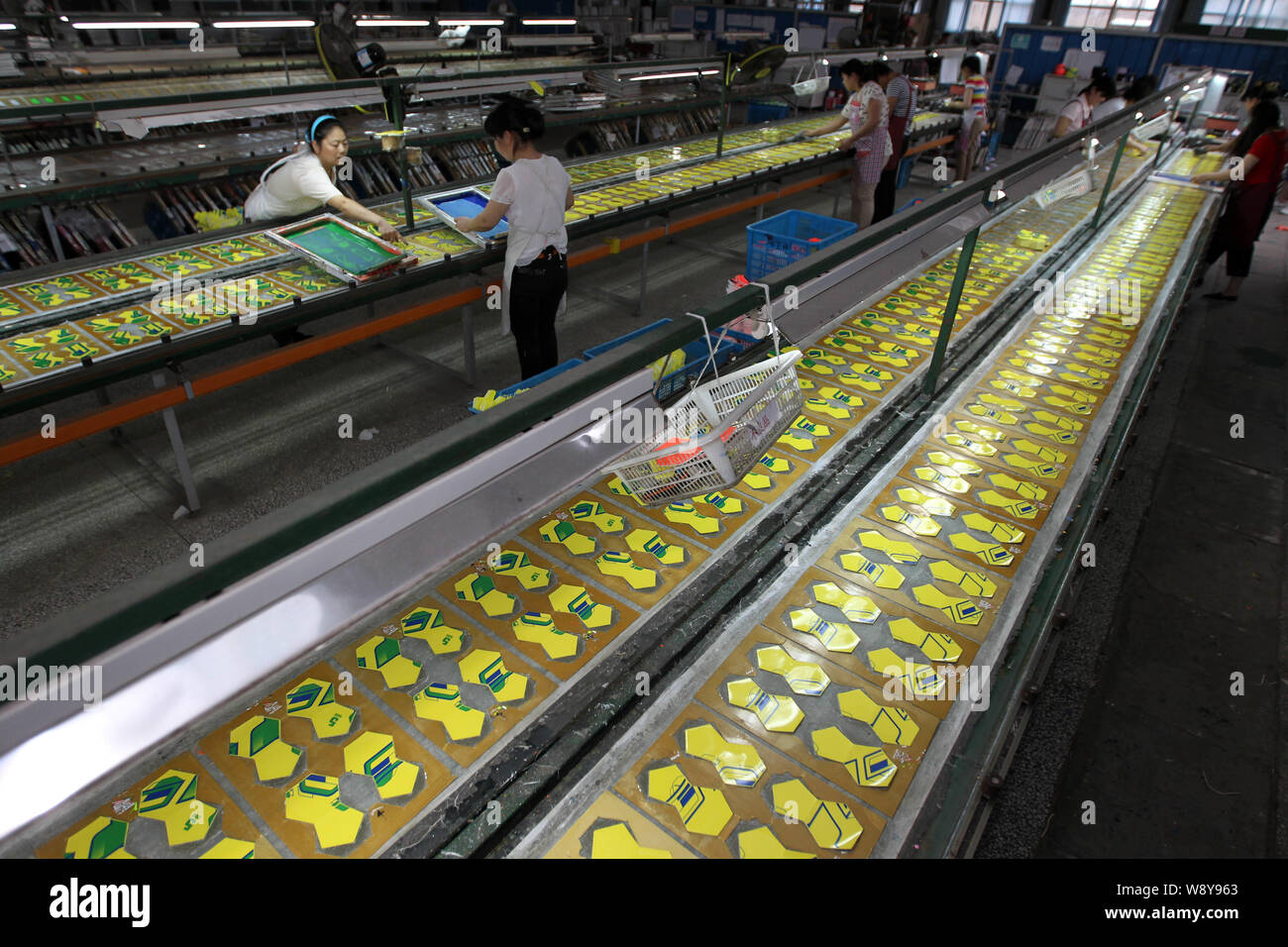 Chinese workers manufacture panels of footballs at a sports goods ...