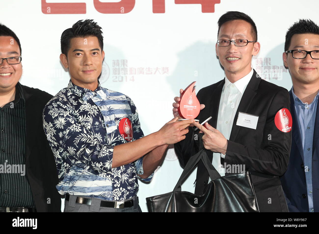 Hong Kong singer and actor Aaron Kwok Fu-shing, second left, presents the trophy for the Best ...
