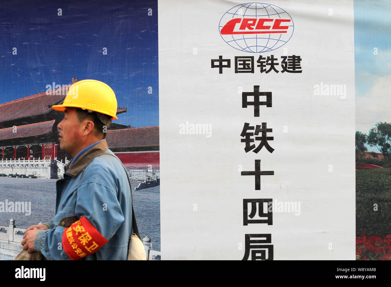 --FILE--A Chinese worker walks past a signboard of CRCC (China Railway ...