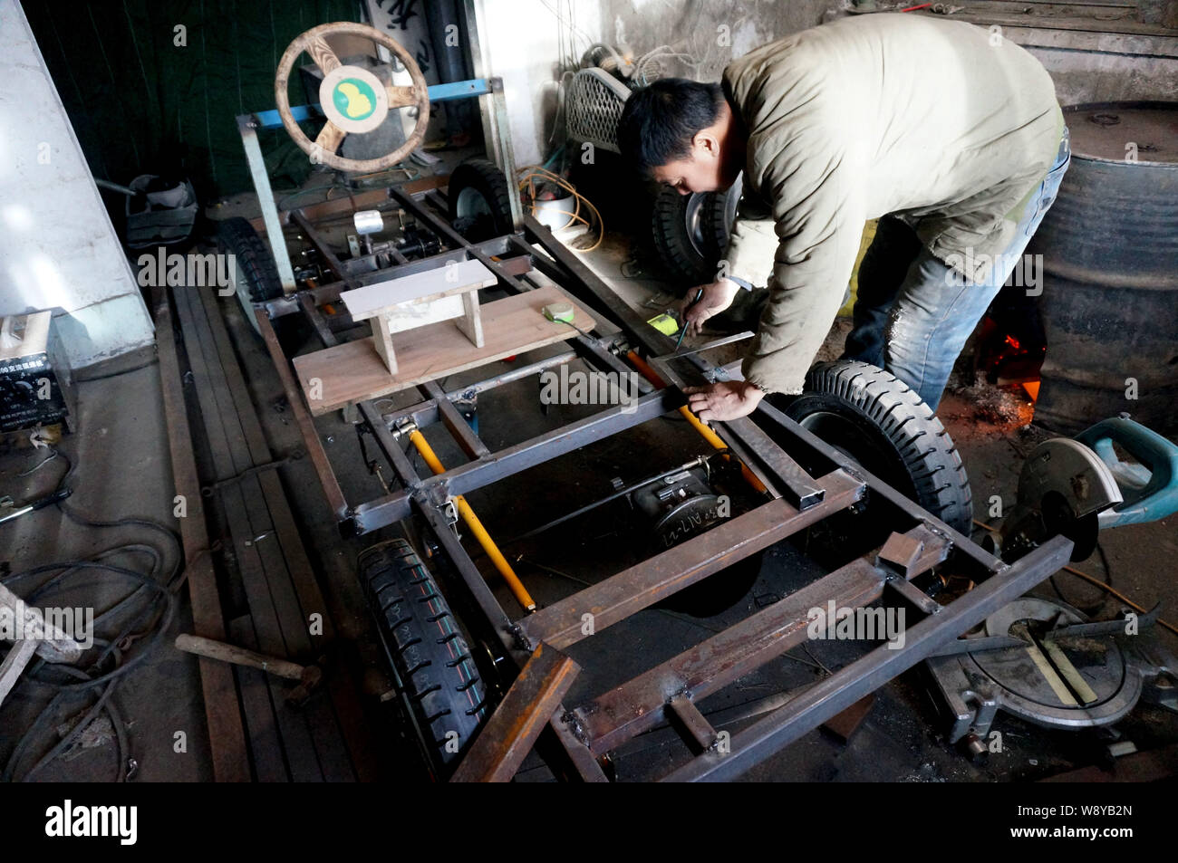 Chinese carpenter Liu Fulong assembles the chassis of his homemade ...