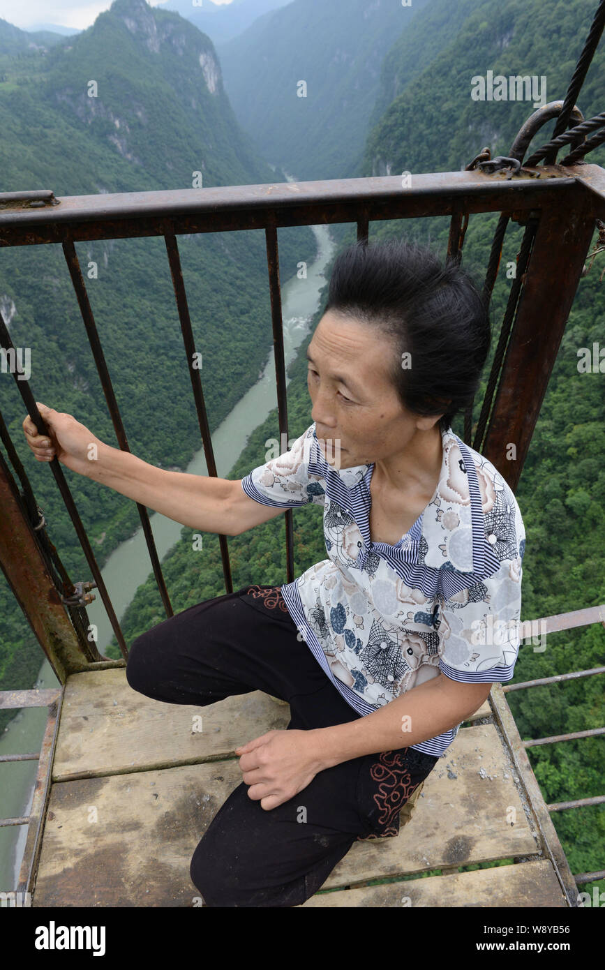 A local Chinese villager rides an iron cage installed on a set of ...