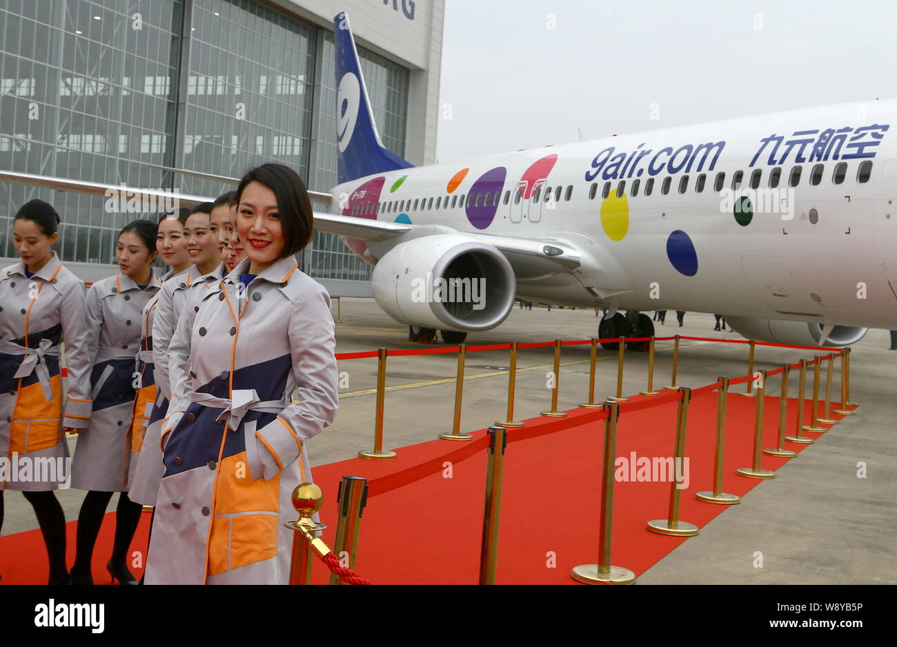 Air hostesses pose in front of a passenger jet of 9 Air during the 9 ...