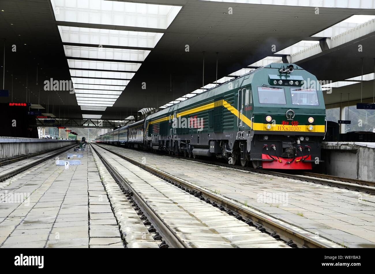 A passenger train leaves the Lhasa Railway Station in Lhasa city ...