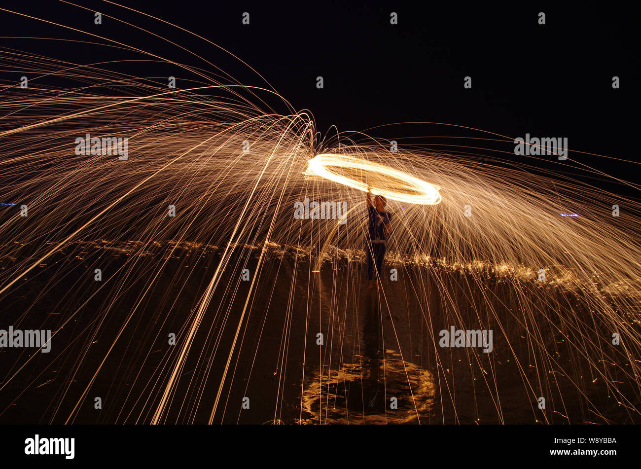In this long-exposure picture, a tourist whirls fireworks to splash ...