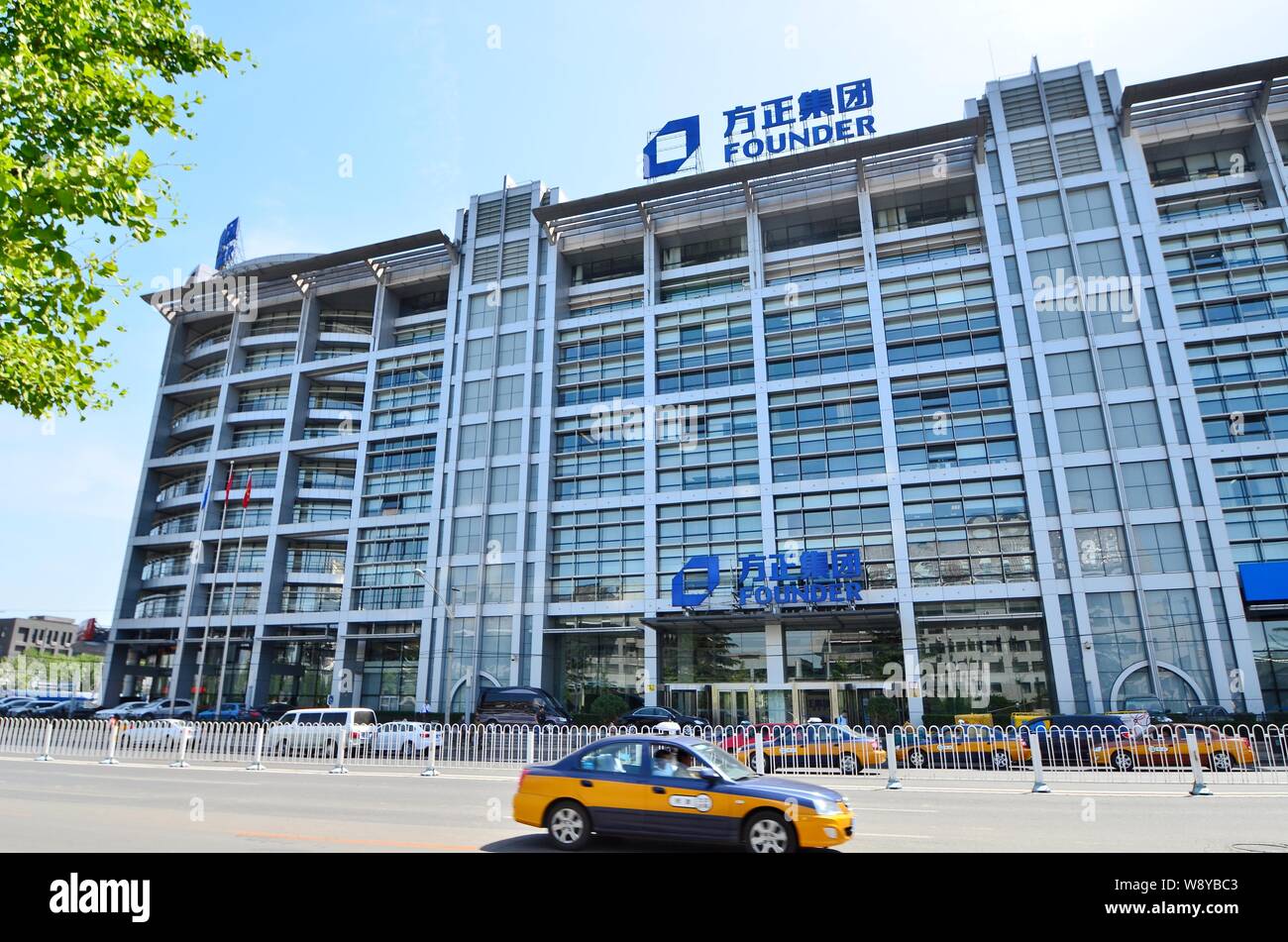 --FILE--Vehicles run past the headquarters building of Founder Group in ...