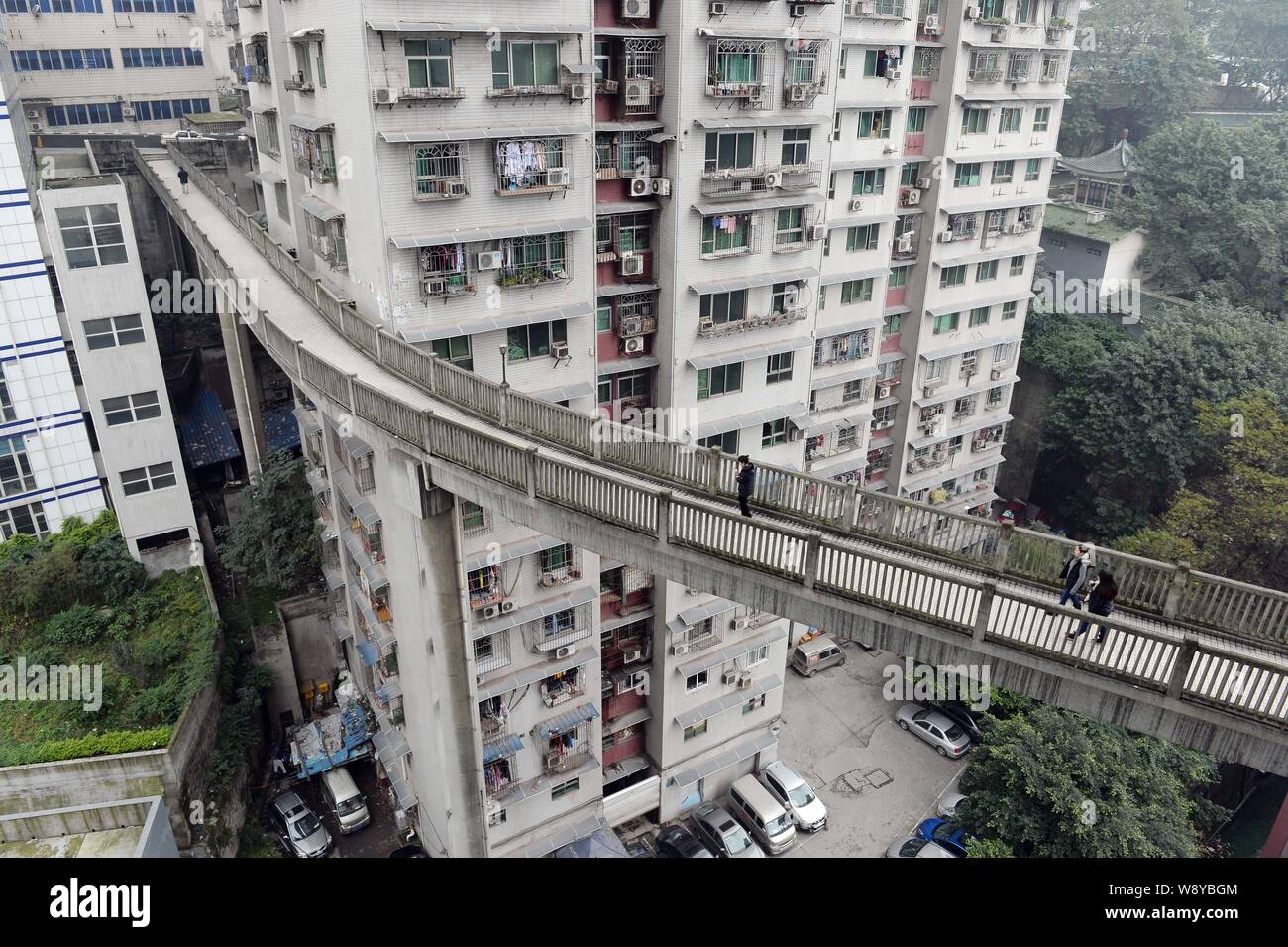 Local Chinese residents walk on the pedestrian bridge linking the 13th ...