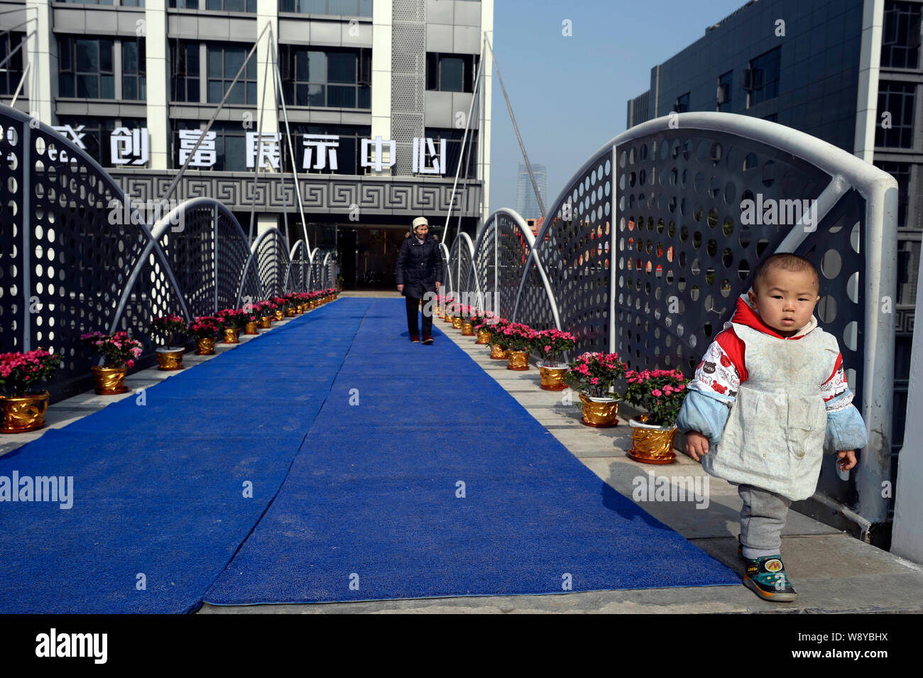 Pedestrians walk on one of the two pedestrian bridges sticking out from ...