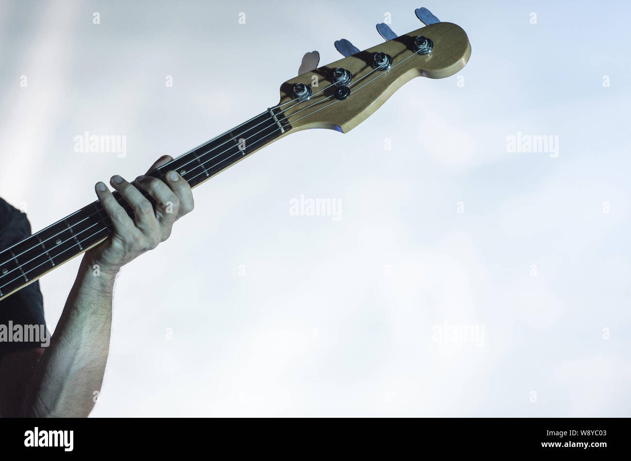 Detail of a musician playing on a bass guitar at concert Stock Photo ...