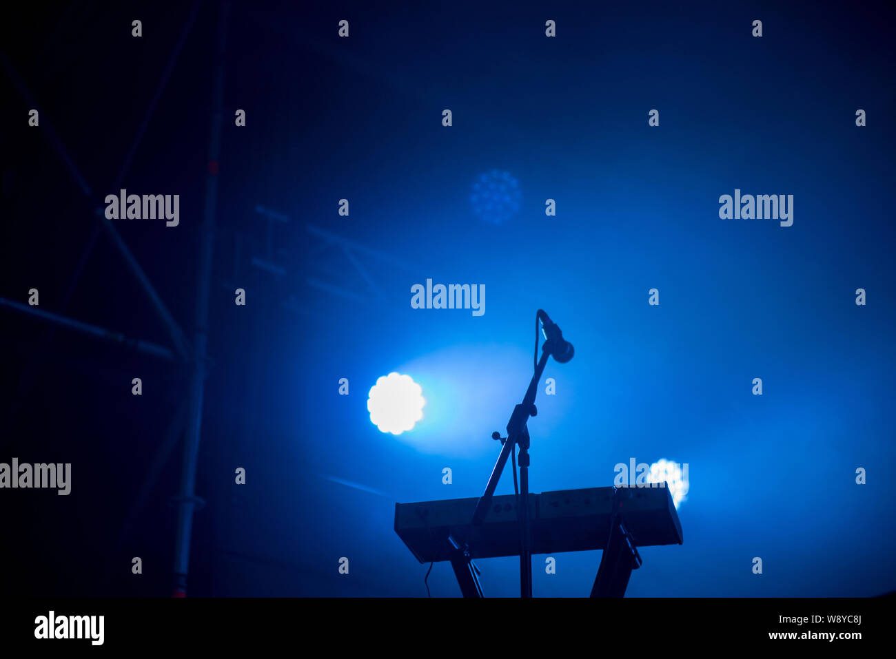 Keyboard and microphone in blue stage lights Stock Photo - Alamy