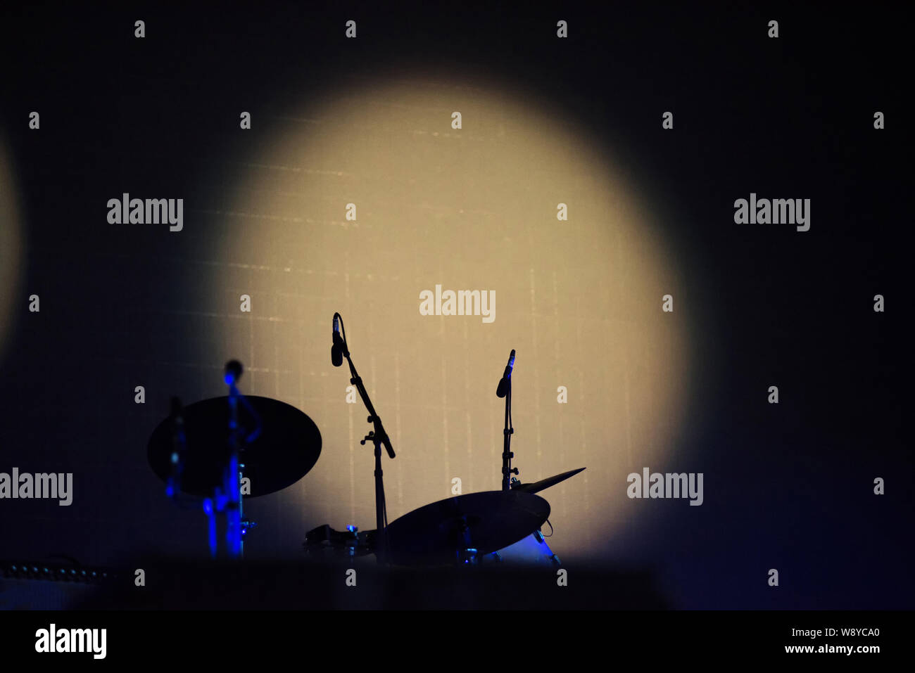 Drum kit illuminated by a spot light on the stage Stock Photo - Alamy