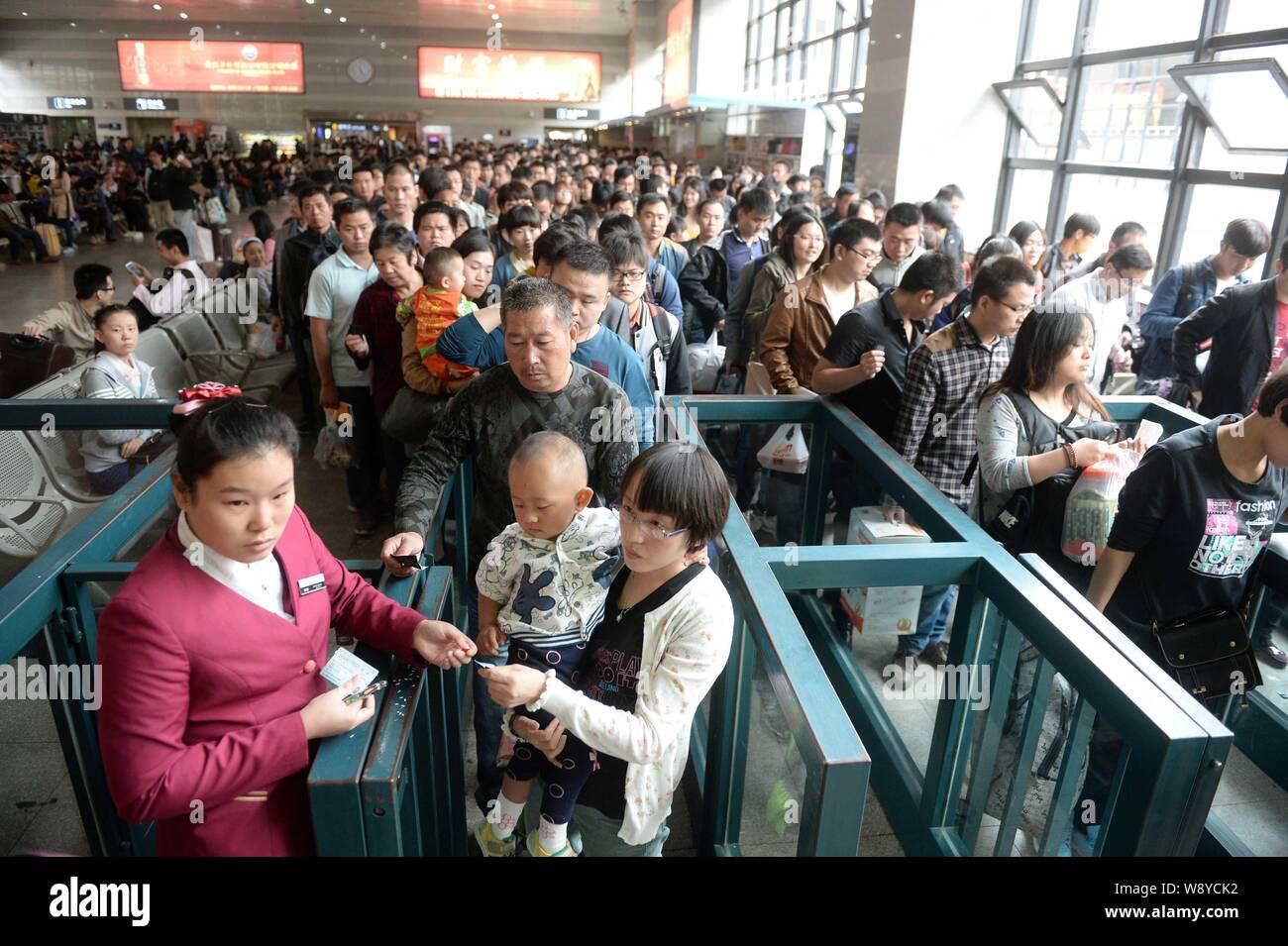 Chinese passengers queue up to check in at the Beijing West Railway ...