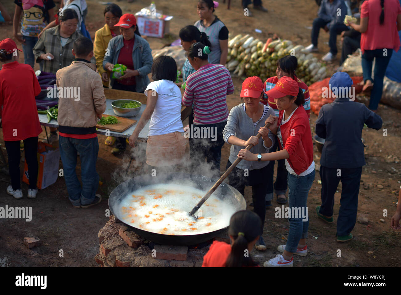Chinese volunteers prepare meals for villagers at a temporary ...