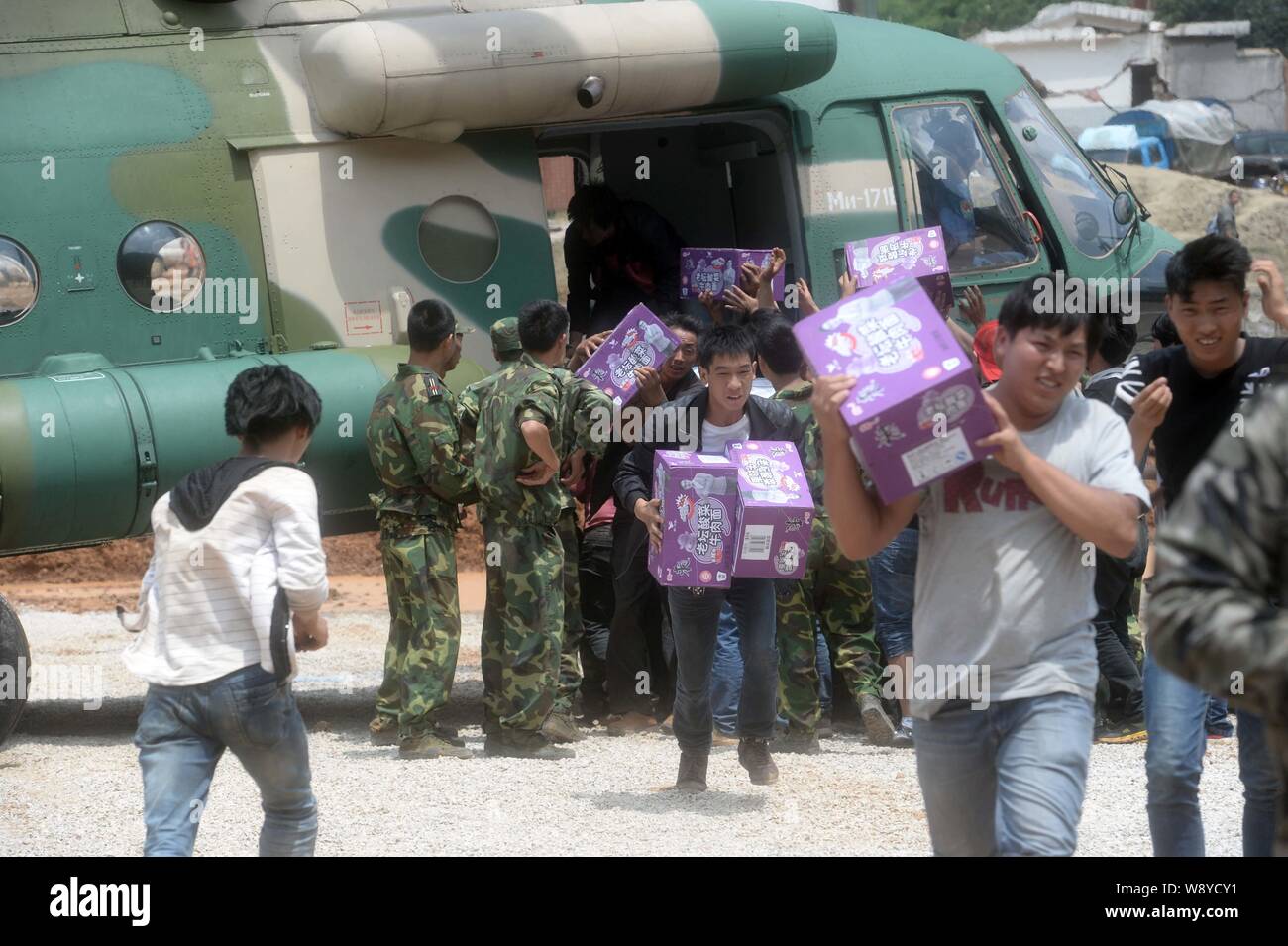 Chinese rescuers and volunteers carry rescue supplies transported by a ...