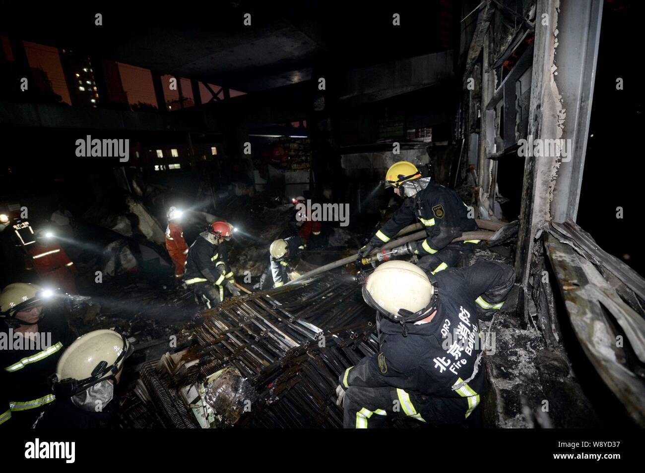 Chinese firefighters hose water to extinguish the fire in an illegal ...