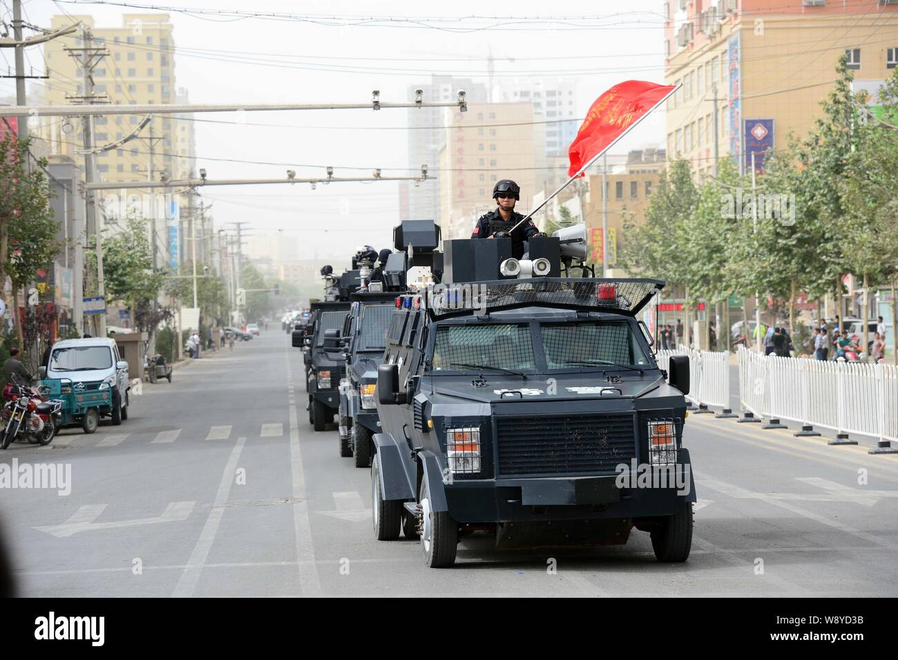 SWAT police officers armed with guns stand on patrol vehicles during a ...