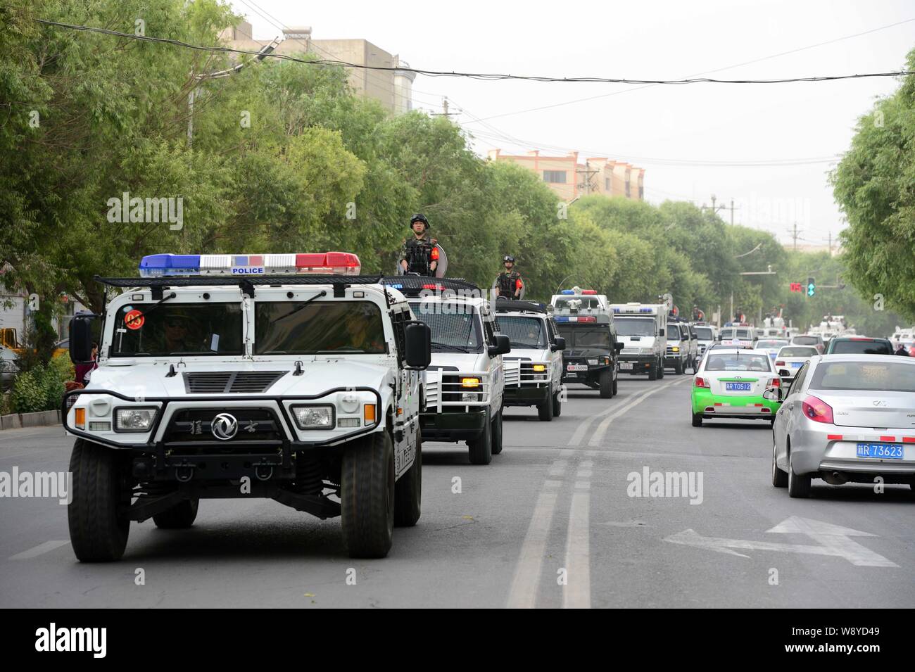 Armed Chinese paramilitary policemen stand on patrol vehicles during a ...