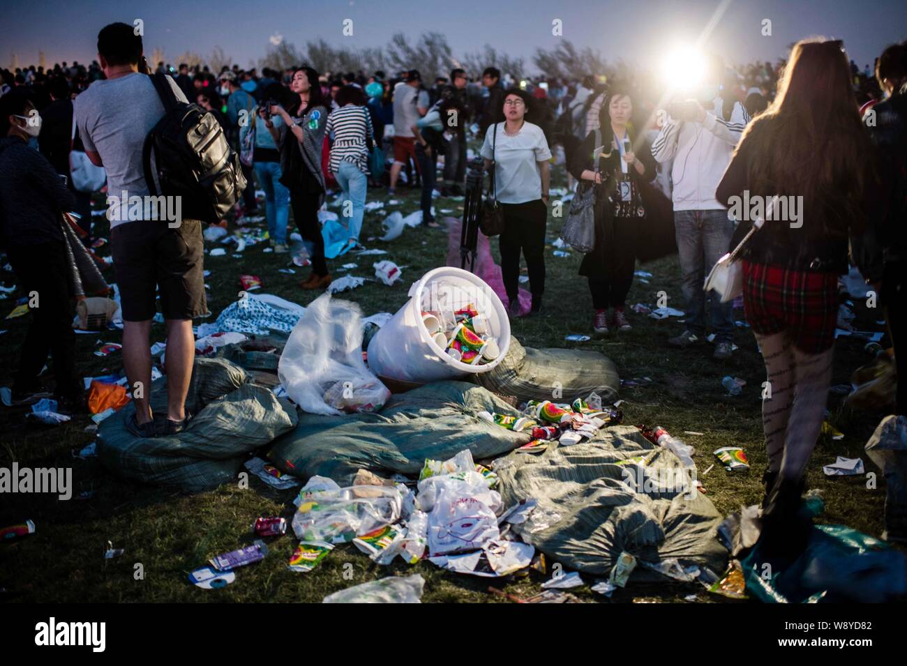 --FILE--People walk on the lawn full of garbage at the Strawberry Music ...