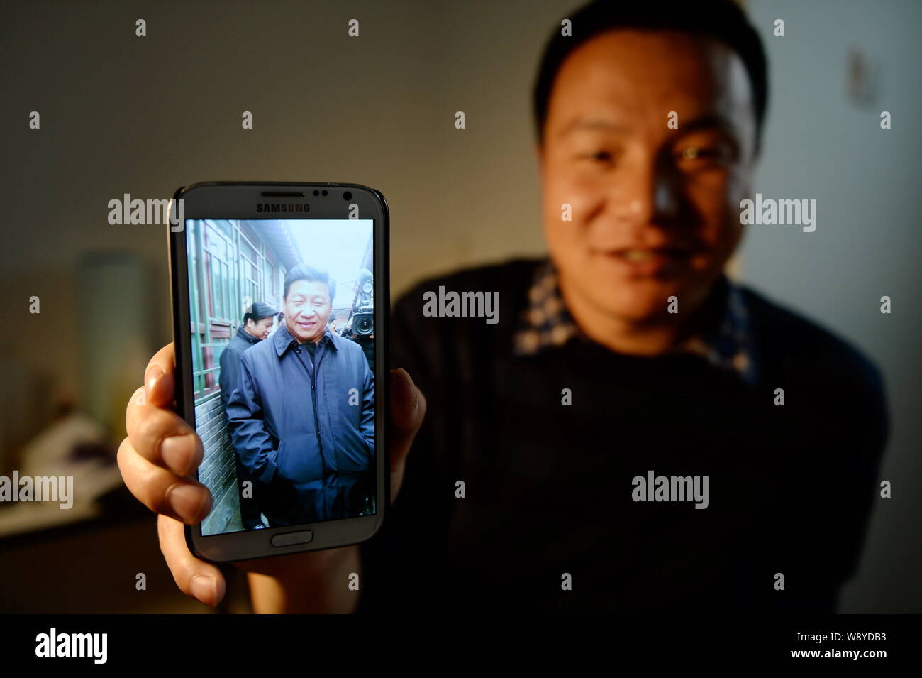 A local Chinese resident shows a photo of Chinese President Xi Jinping ...