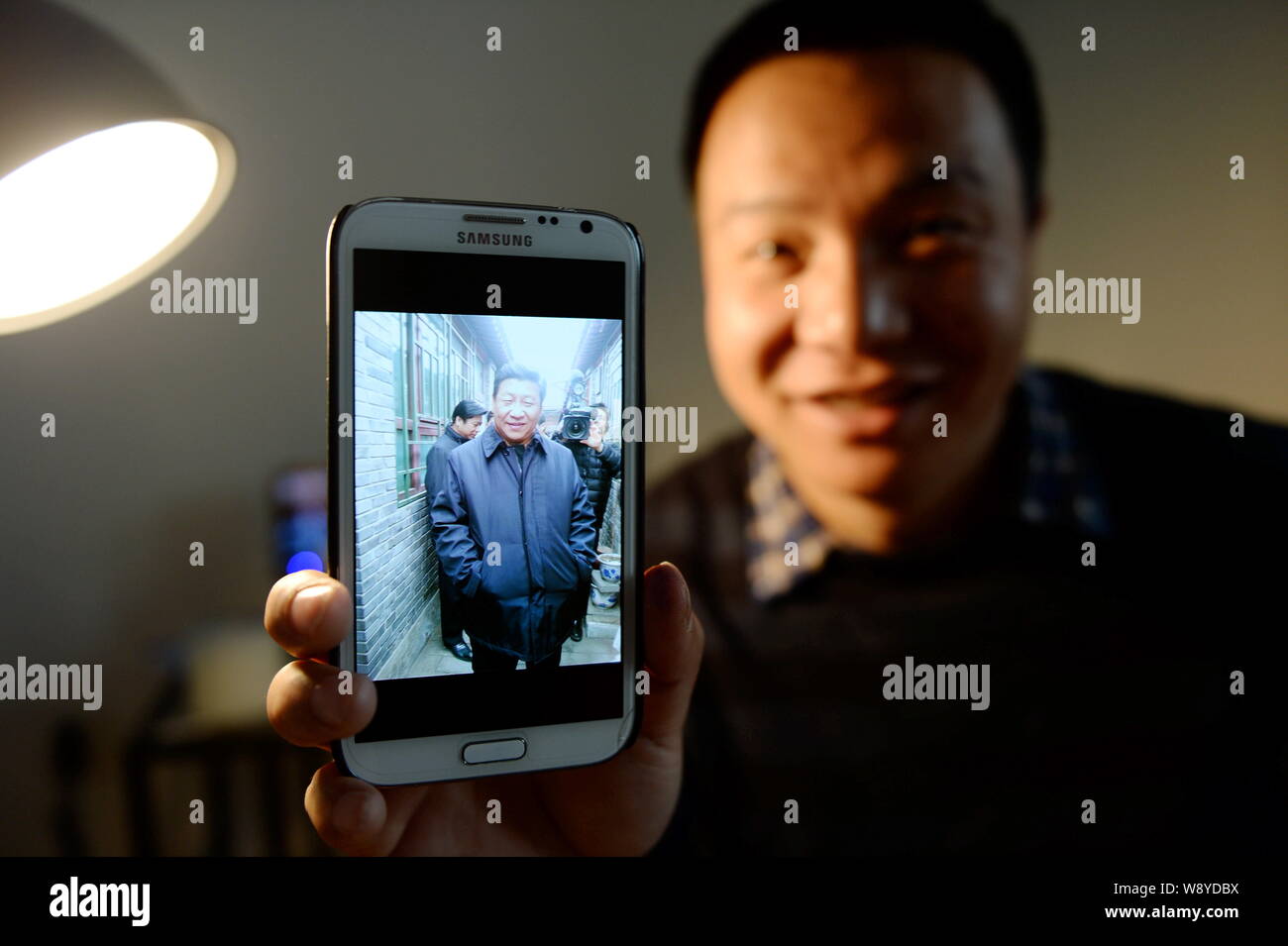 A local Chinese resident shows a photo of Chinese President Xi Jinping ...