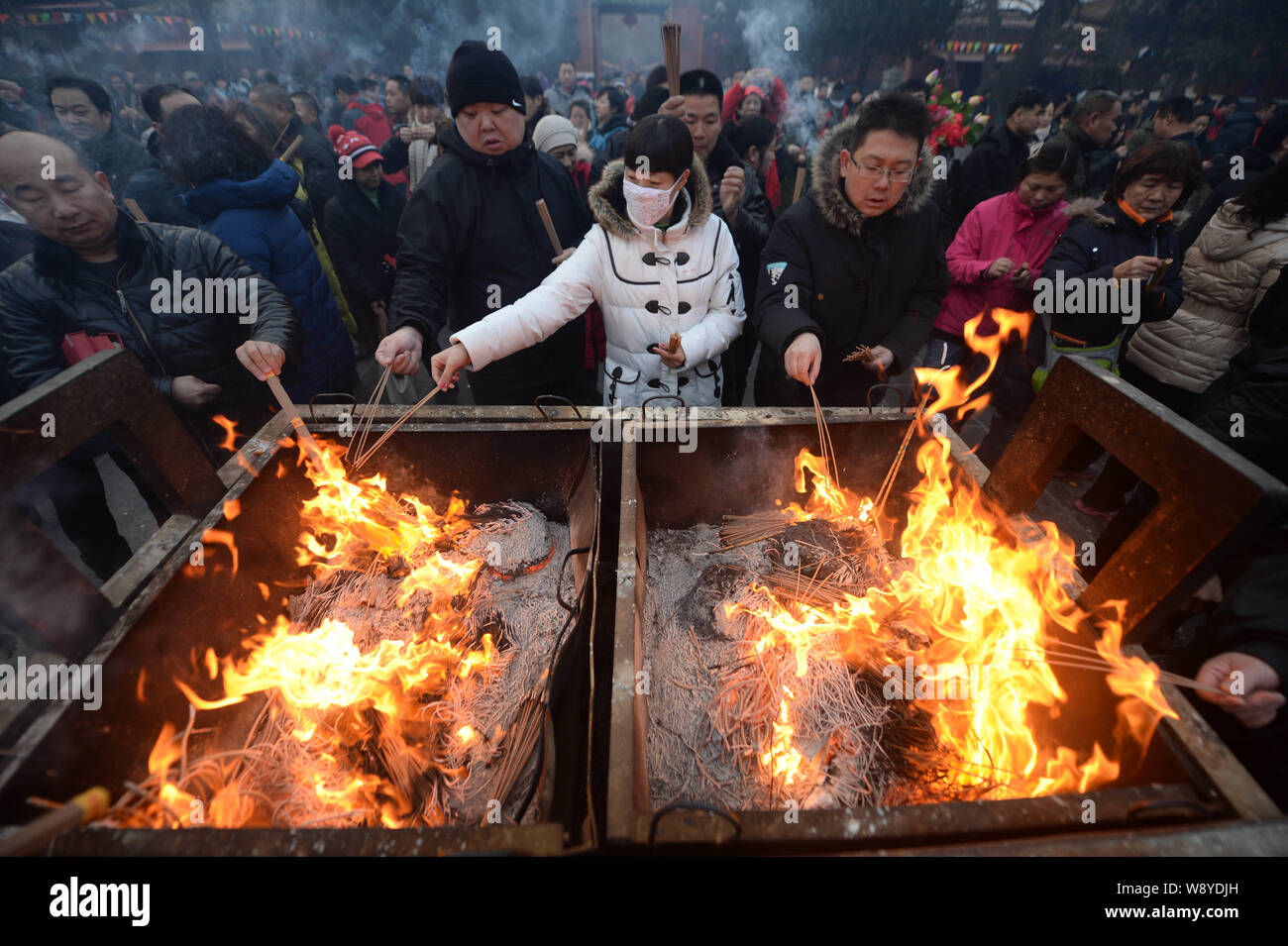 Chinese worshippers burn incense sticks to pray for good fortune and ...