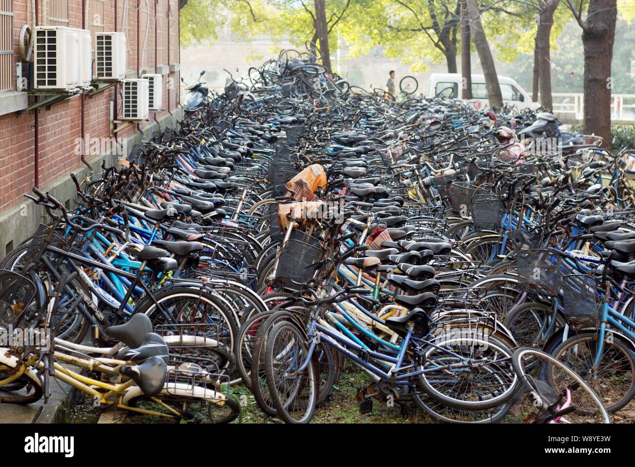 Discarded bicycles are parked in front of a dorm building at Central ...