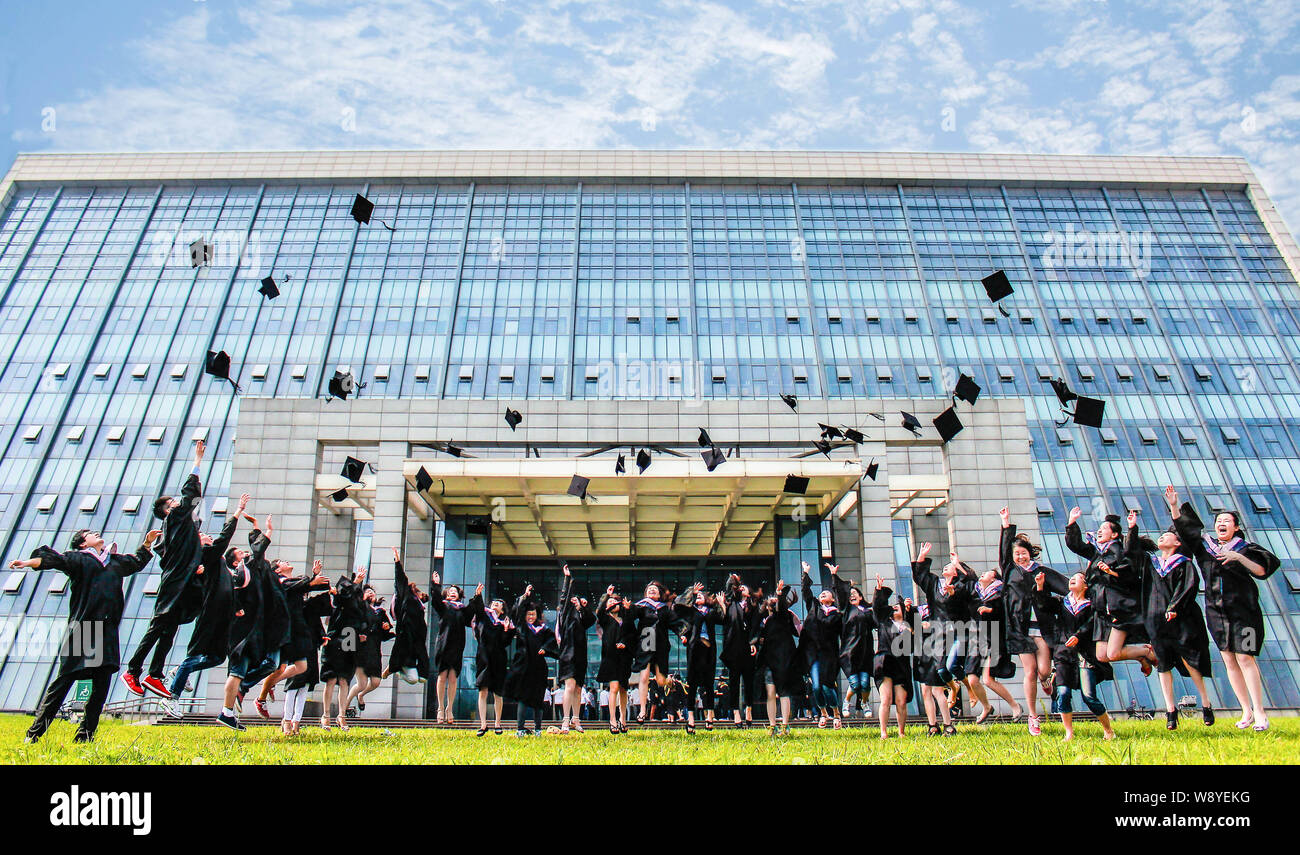 --FILE--Chinese graduates dressed in academic gowns throw hats into the ...