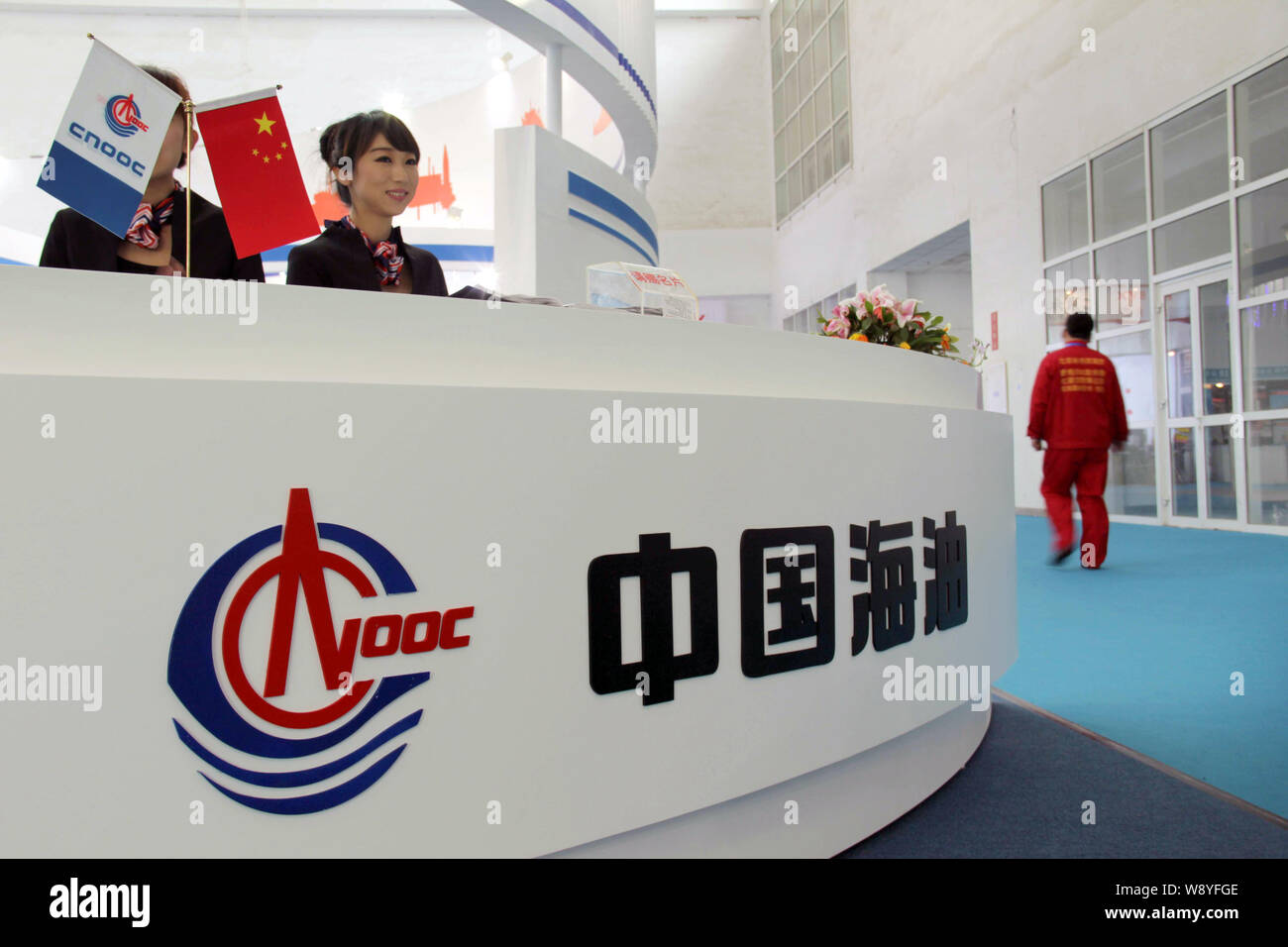 --FILE--Chinese employees are seen at the stand of CNOOC (China ...