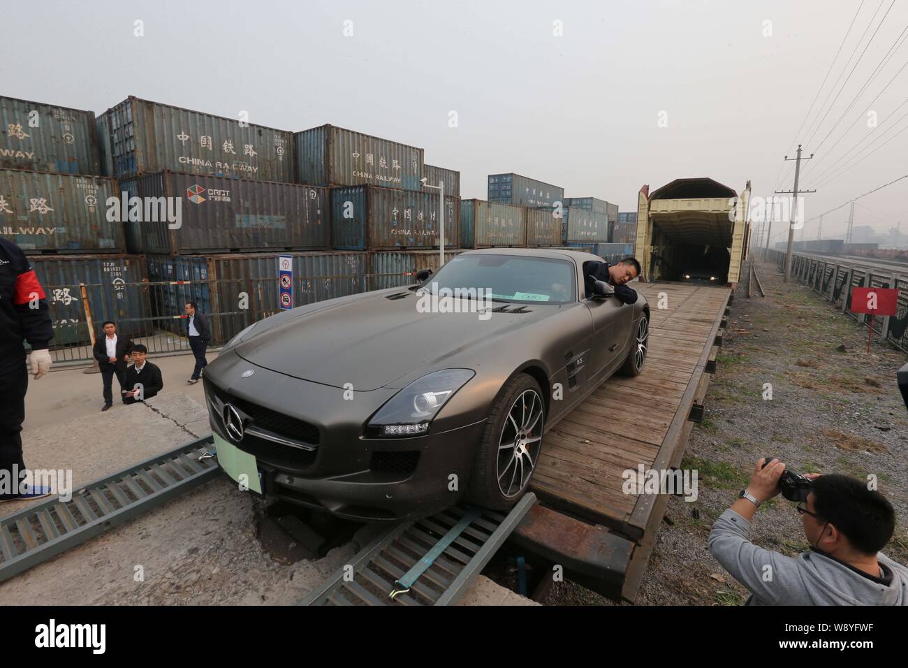 A worker drives a luxury Mercedes-Benz SLS sports car out of a freight ...