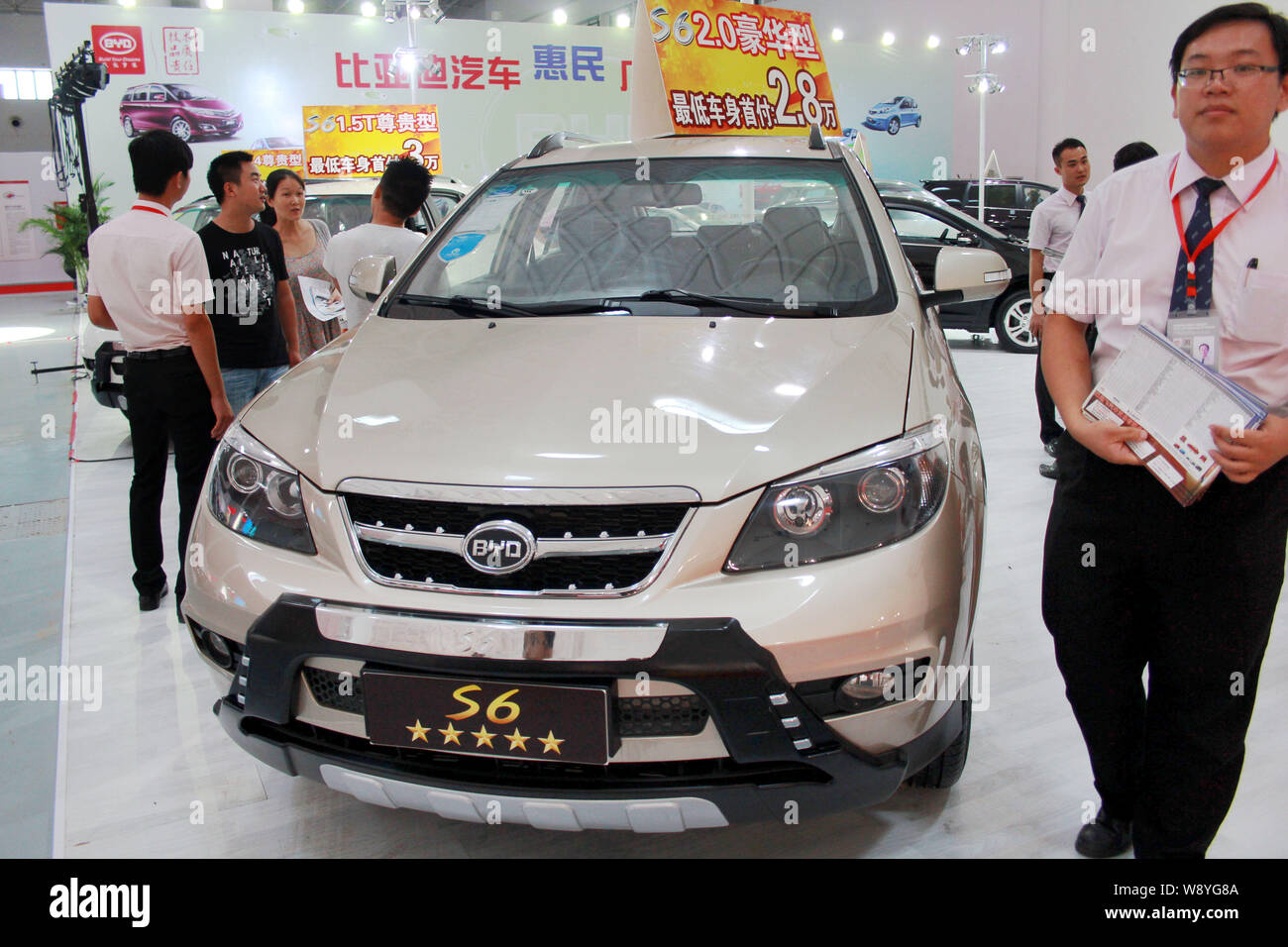 --FILE--A Chinese employee stands next to a BYD S6 during an auto show ...