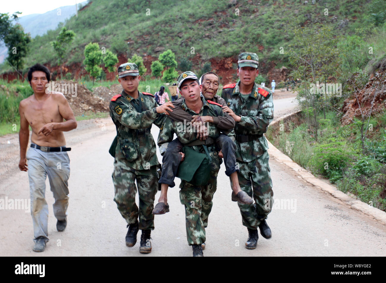 A Chinese rescuer carries a villager who was injured in the 6.5 ...