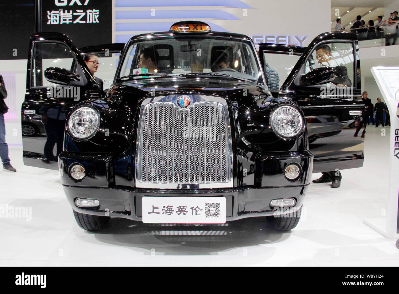 --FILE--Visitors try out a Geely Englon TX4 taxi on display during the ...