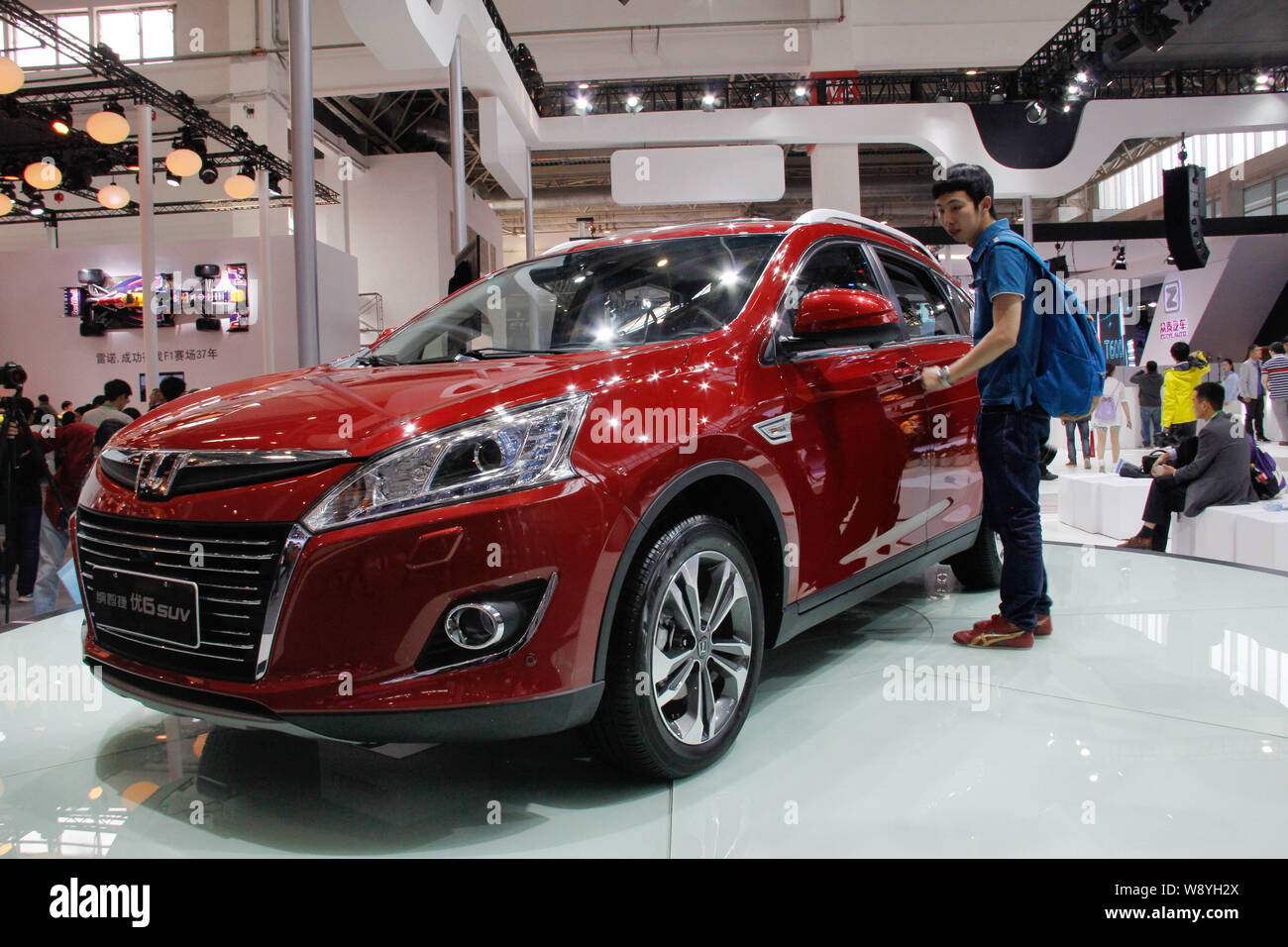 --FILE--A visitor looks at a Luxgen U6 SUV of Dongfeng Motor during the ...