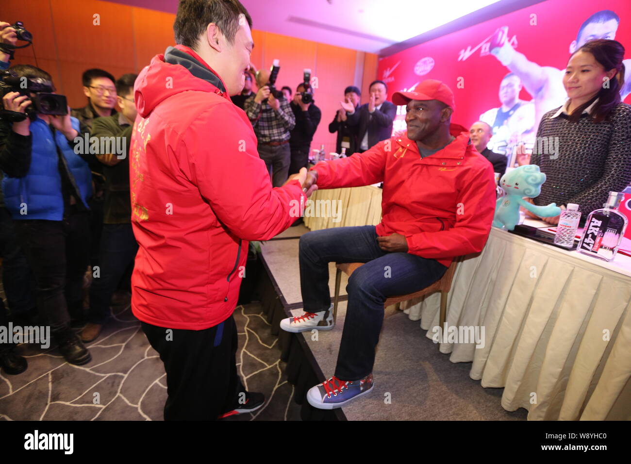 Chinese professional boxer Zhang Junlong, left, shakes hands with retired U.S. boxer Evander ...