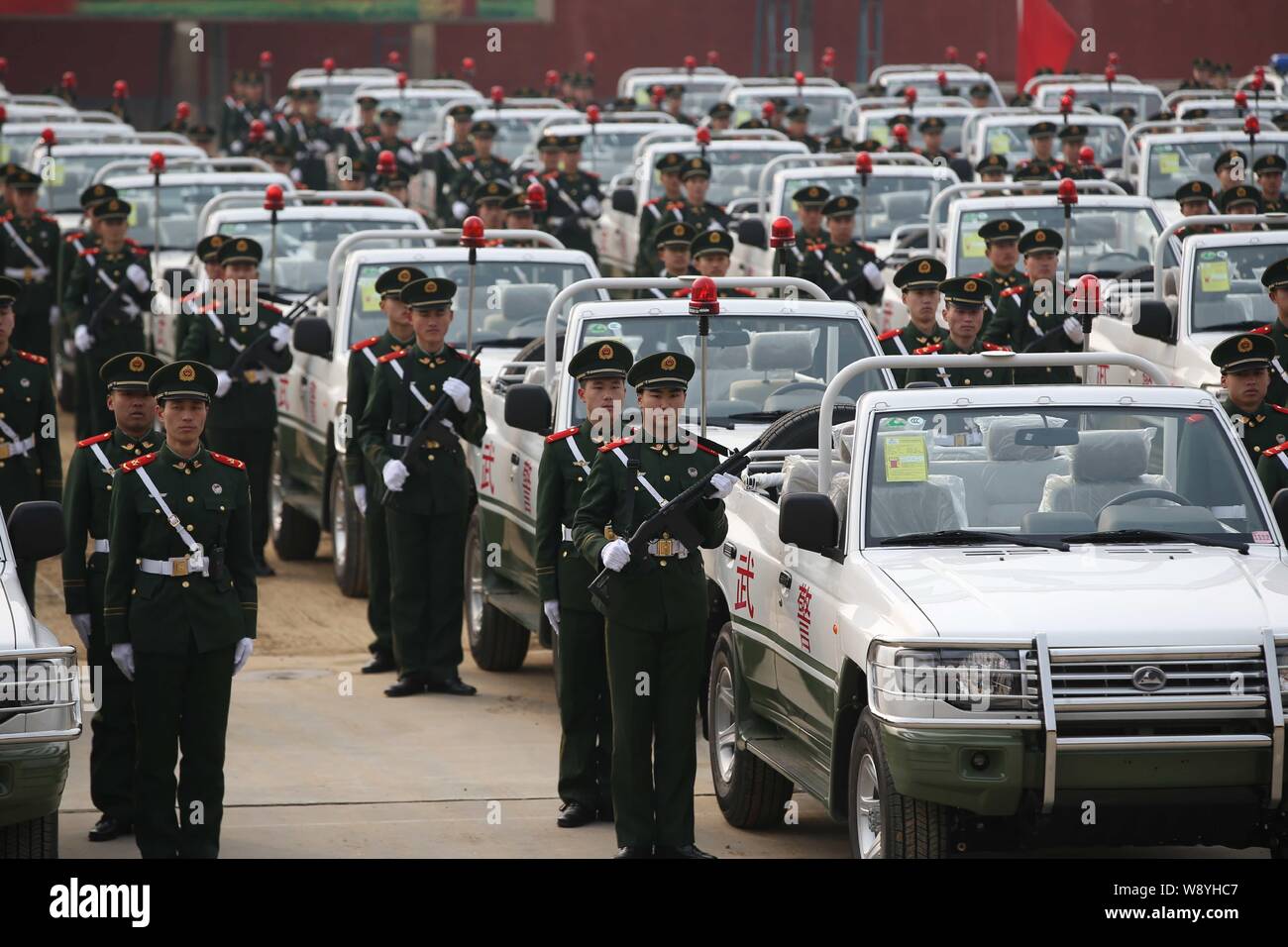 Chinese paramilitary policemen stand next to their patrol cars in ...