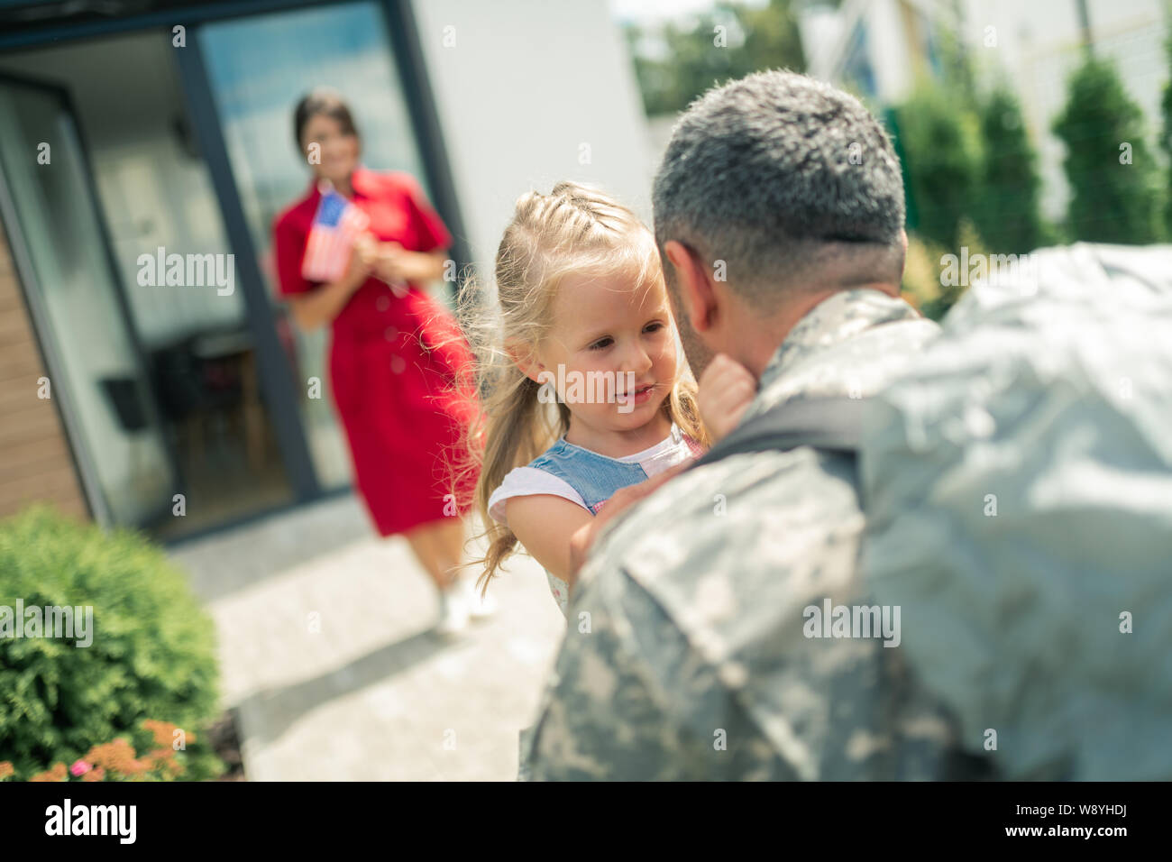 Military man coming back home and seeing his wife and daughter Stock ...